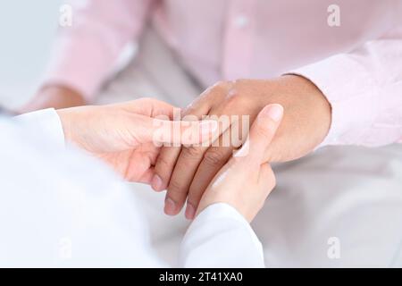 Doctor checking man's hand Stock Photo - Alamy