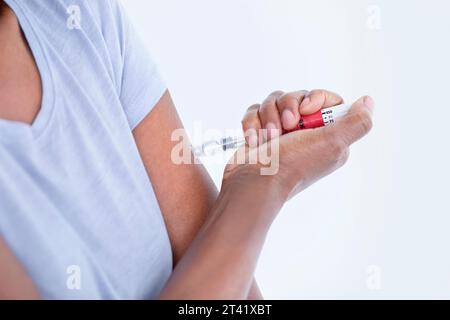 Insulin pen. Woman self-administering insulin with a hypodermic syringe ...