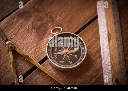 Vintage ruler, drawing and navigational Compass on a rustic wooden ...