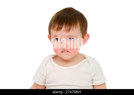 Offended baby looks pursed lips, studio white background. Sad child ...