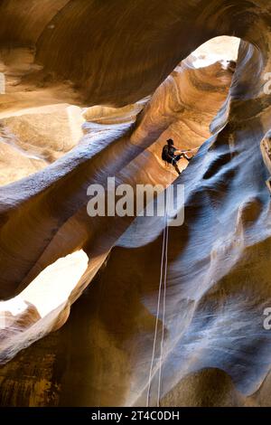 Silhouette of a Unrecognizable man rappelling down a steep cliff on the ...