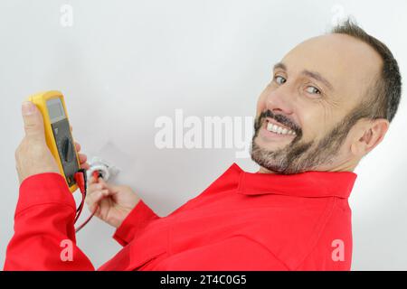 happy electrician checking socket voltage Stock Photo - Alamy