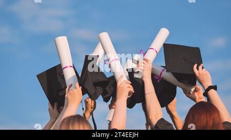 College graduates raise their caps and diplomas upward Stock Photo - Alamy