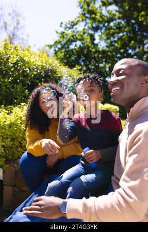 Happy parents and their little son in Santa hats with noisemakers on ...