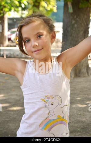 Cute kid girl 10 year old posing on nature background. Looking at ...