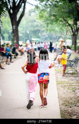 Two beautiful Filipino girls clearly best friends saunter merrily ...