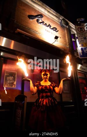 woman performs fire breathing and eating during the halloween weekend ...