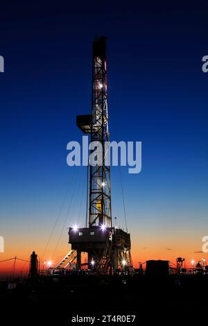 Oil drilling derrick and lights in oilfield Stock Photo - Alamy