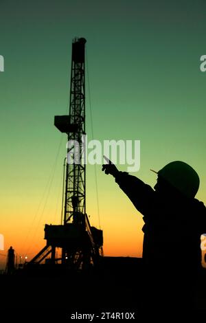 Oil drilling frame and exploration technician in a oilfield Stock Photo ...
