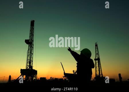 Oil drilling frame and exploration technician in a oilfield Stock Photo ...