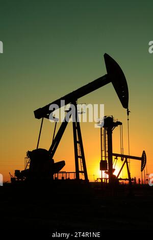 Beam balanced pumping unit under the setting sun in oilfield Stock ...