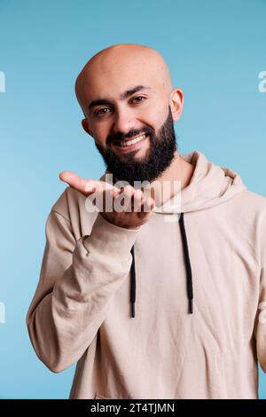 Arab man blowing air kiss with charming smile and looking at camera ...