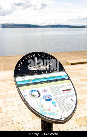 Tourist looking at one of the Clyde Sea Lochs Trail information panel's ...