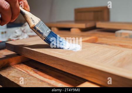 Varnishing a wooden drawer, carpentry workshop. Varnish is applied to a ...