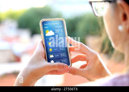 Woman outdoors checking the weather forecast on an app on her mobile ...