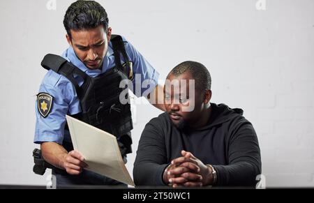 Criminal in handcuffs talking to policeman in interrogation room Stock ...