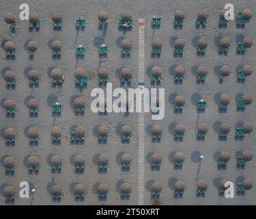 Aerial view of large group of tidy beach umbrellas facing the ...