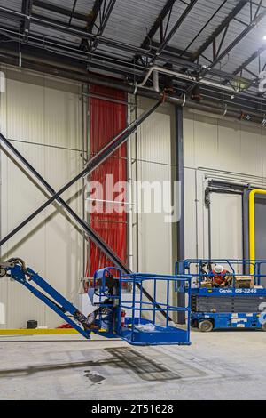 Red coolant hoses descend from the roof of a cold-storage facility to ...