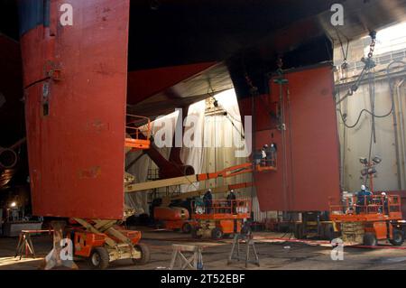 Shipyard workers at Newport News Shipbuilding prepare a launch engine ...