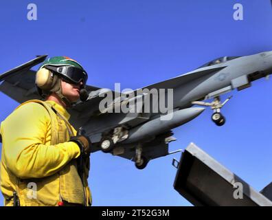 An F/A-18 lands with its arresting gear in the down position. Base ...