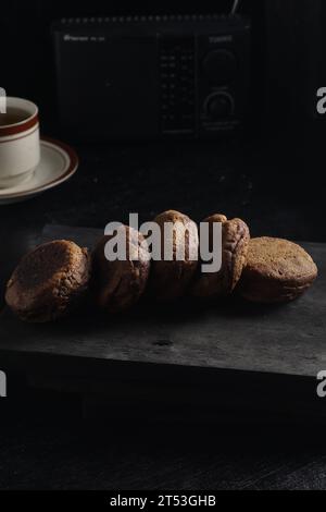 Apang bale cake or Apang bakar, and a cup of tea isolated on black ...