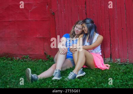 Two teen girls lean on each other over white studio background Stock ...