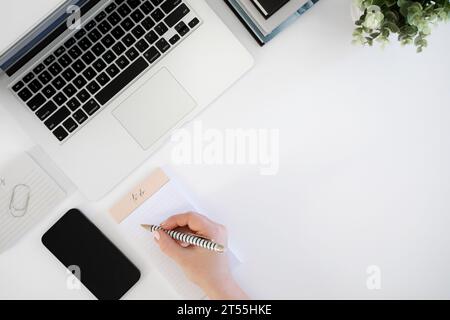 Hand writing notes next to a laptop computer on desk with props Stock ...