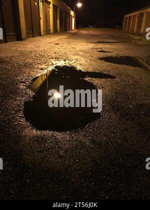 The moon reflecting at night in a puddle on the road Stock Photo - Alamy