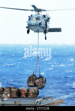 An MH-60S Sea Hawk lifts cargo from USNS Supply during a replenishment ...