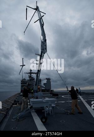 Contractors recover a Scan Eagle UAV on the flight deck of USS Gunston ...