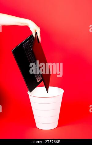 Black laptop in a trash bin on a red background isolated Stock Photo ...
