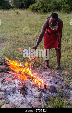 Masai man cooking Stock Photo - Alamy