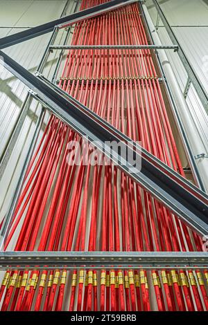 Red coolant hoses descend from the roof of a cold-storage facility to ...