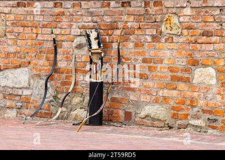 Bows and arrows leaning against a brick wall Stock Photo - Alamy
