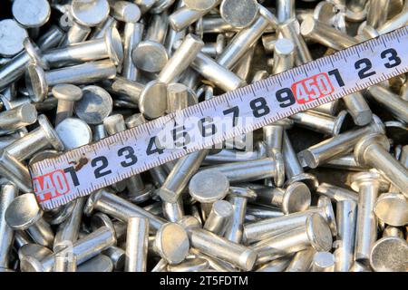 new rivet and tape measure piled up together Stock Photo - Alamy