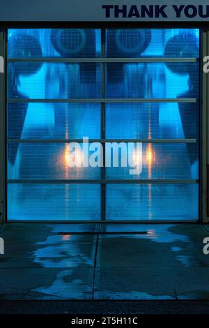 Automatic car wash exit overhead door at night Stock Photo - Alamy