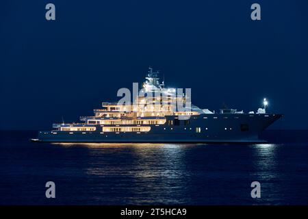 The 107m superyacht Ulysses at anchor off Antibes at night showing all ...