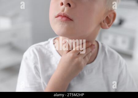 Endocrine system. Little boy doing thyroid self examination on light ...