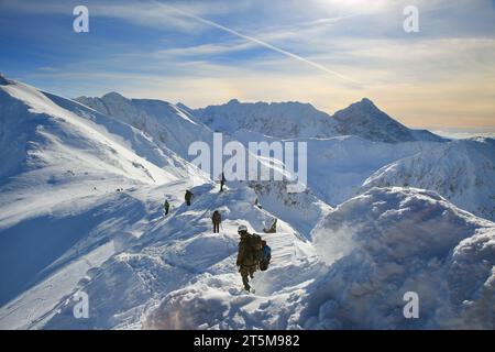 Tied climbers climbing mountain with snow field tied with a rope with ...
