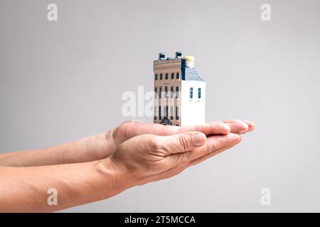 Hand holding a model mansion house. Real estate or property concept ...