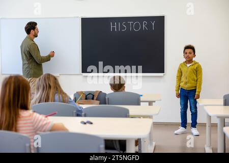 Teacher introducing a new boy to the classmates Stock Photo - Alamy