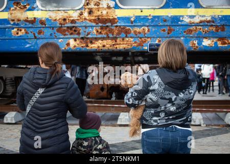 People look at a destroyed railway carriage used to evacuate people ...