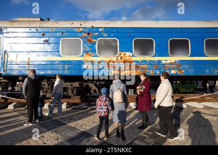 People look at a destroyed railway carriage used to evacuate people ...