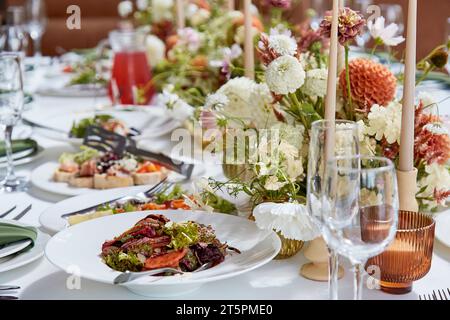 Graceful autumn aesthetics table setting and food, arranged flowers ...