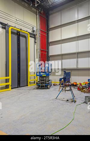 Red coolant hoses descend from the roof of a cold-storage facility to ...