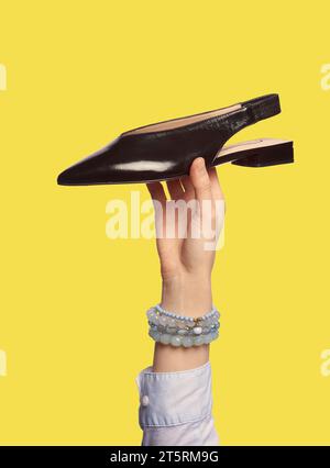Hand holding black shoe isolated on white background Stock Photo - Alamy