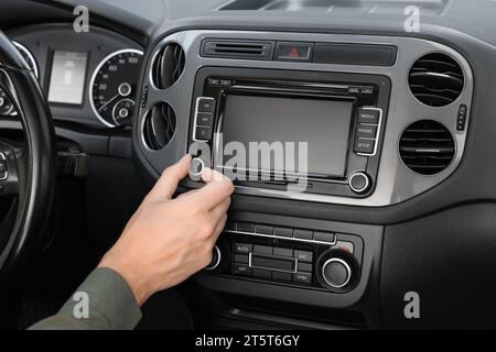 Listening to radio while driving. Man turning volume button on vehicle ...