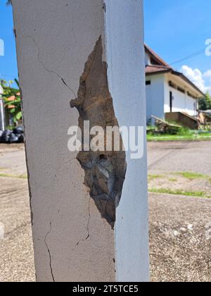 Cracks in damaged building pillars. Cracked concrete pillar of an old house. Deep and clear ...