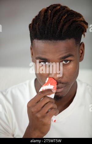 young african american man with bleeding face and broken nose holding ...