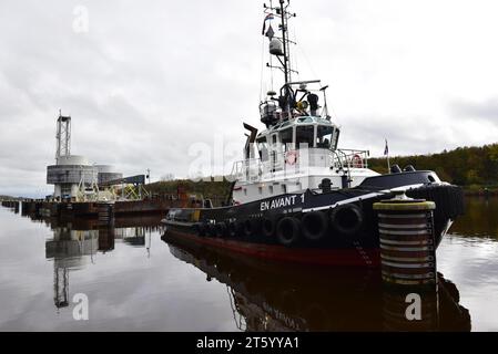 Tugboat towing a pontoon with offshore installation in the Kiel Canal ...